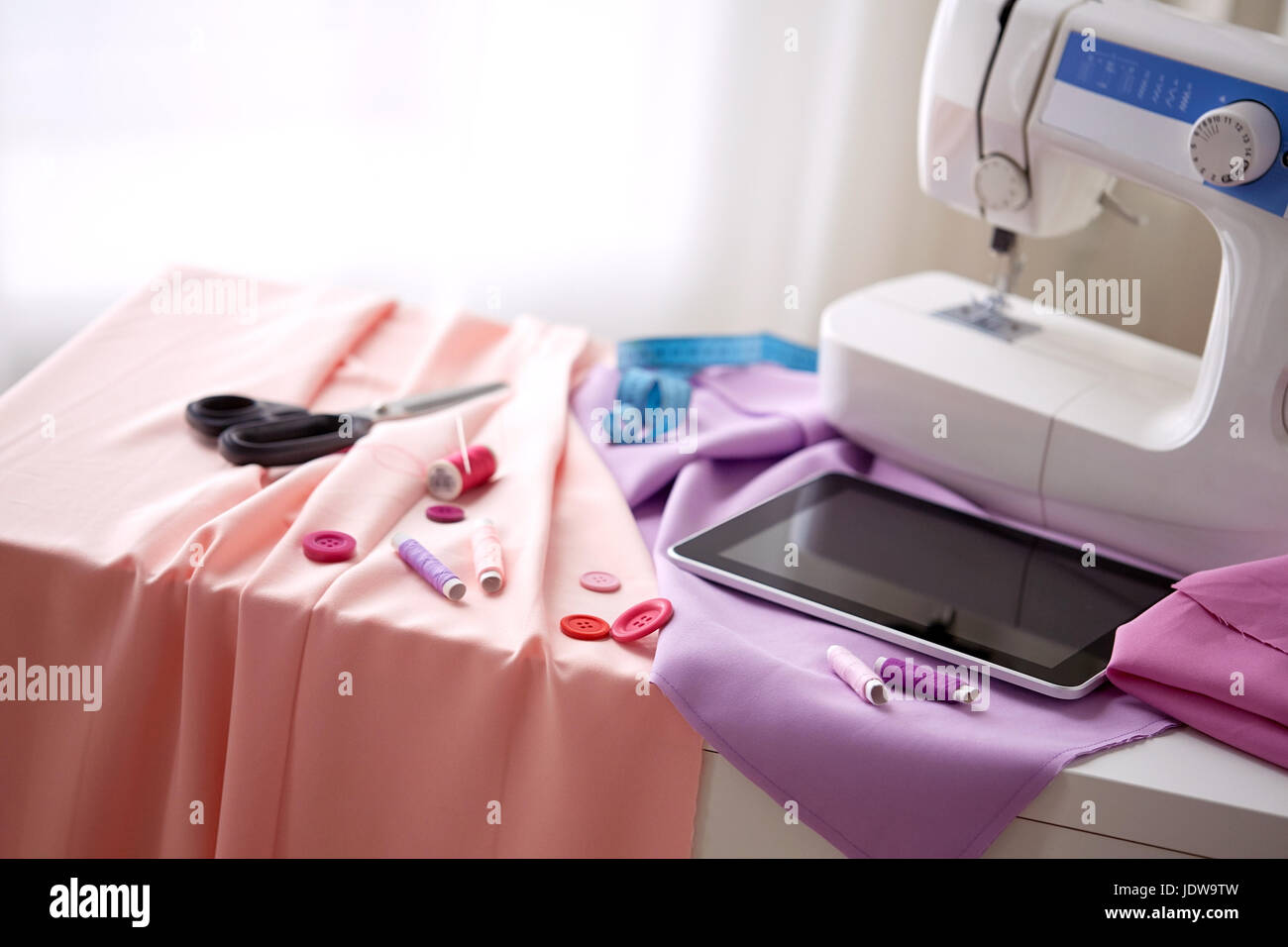 sewing machine, tablet pc, scissors and ruler Stock Photo - Alamy