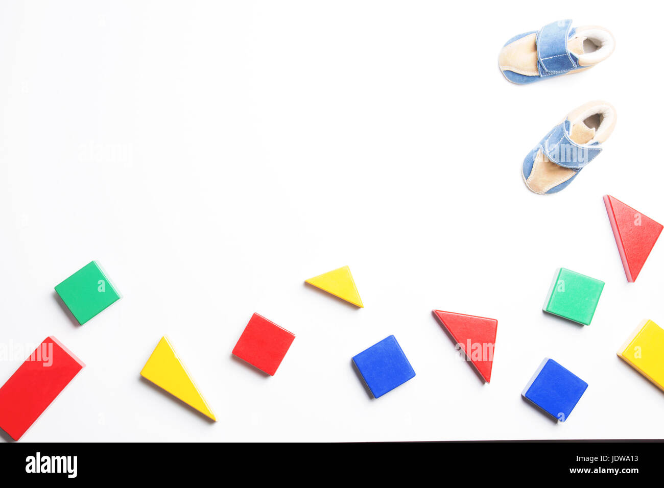 Colorful wooden blocks and baby shoes on white background Stock Photo ...