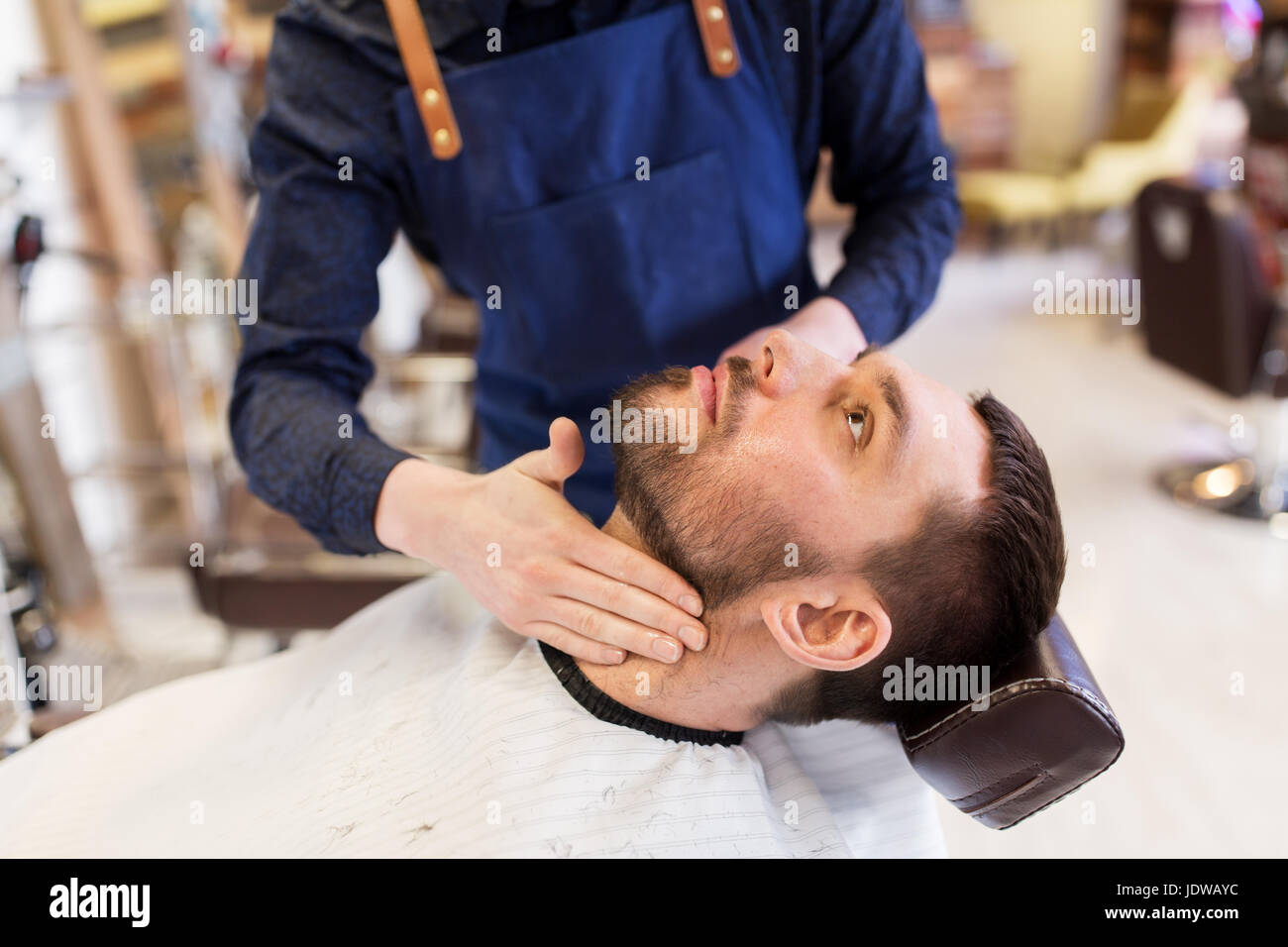 barber applying aftershave lotion to male neck Stock Photo - Alamy