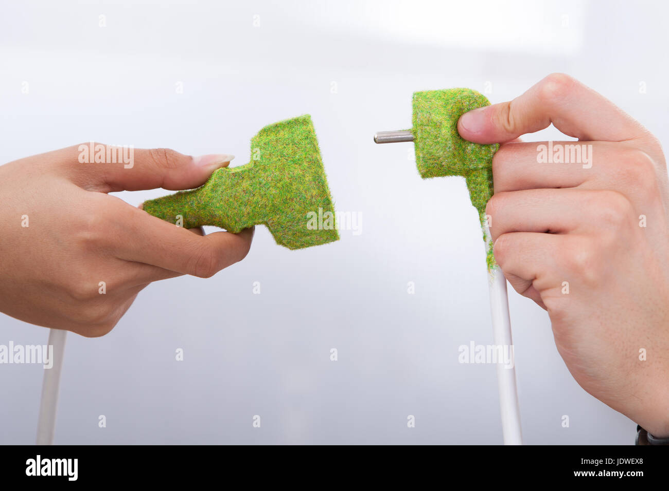 Cropped image of hands fixing green plugs Stock Photo - Alamy