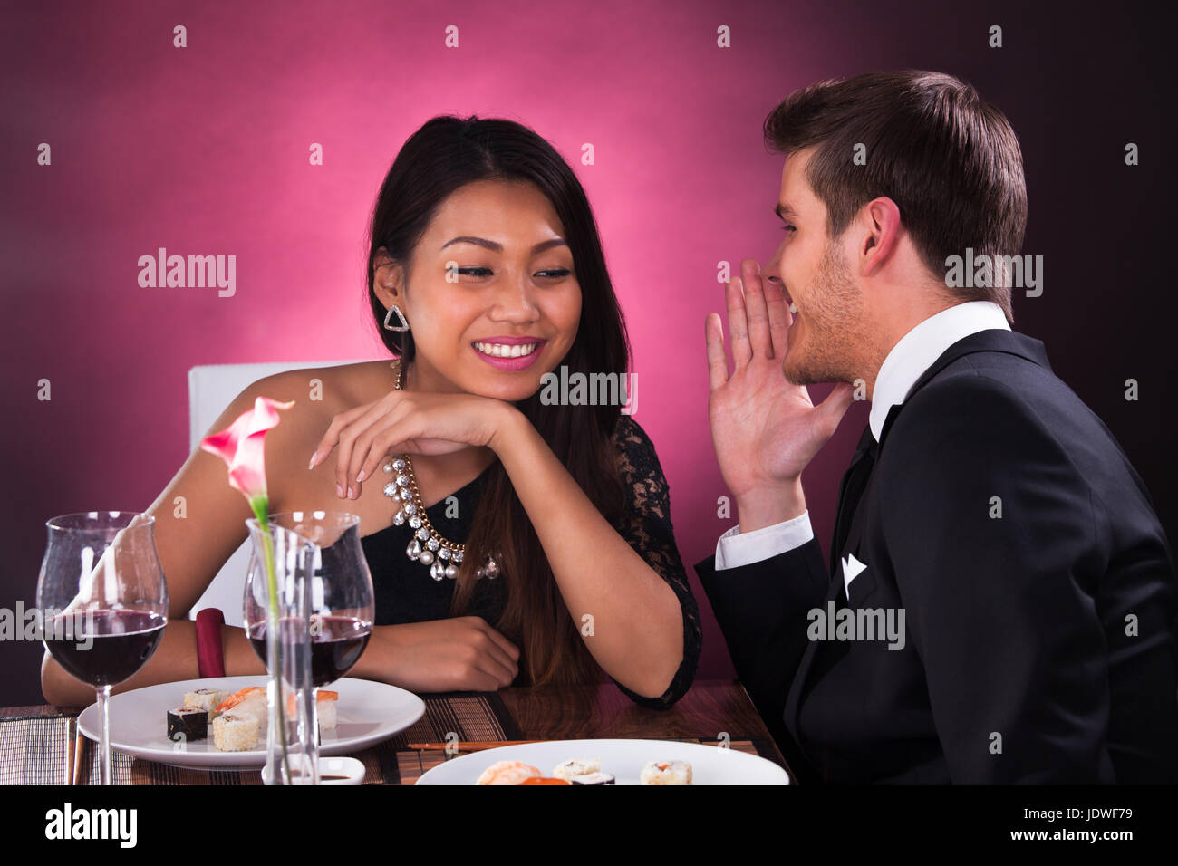 Man whispering in womans ear hi-res stock photography and images - Alamy