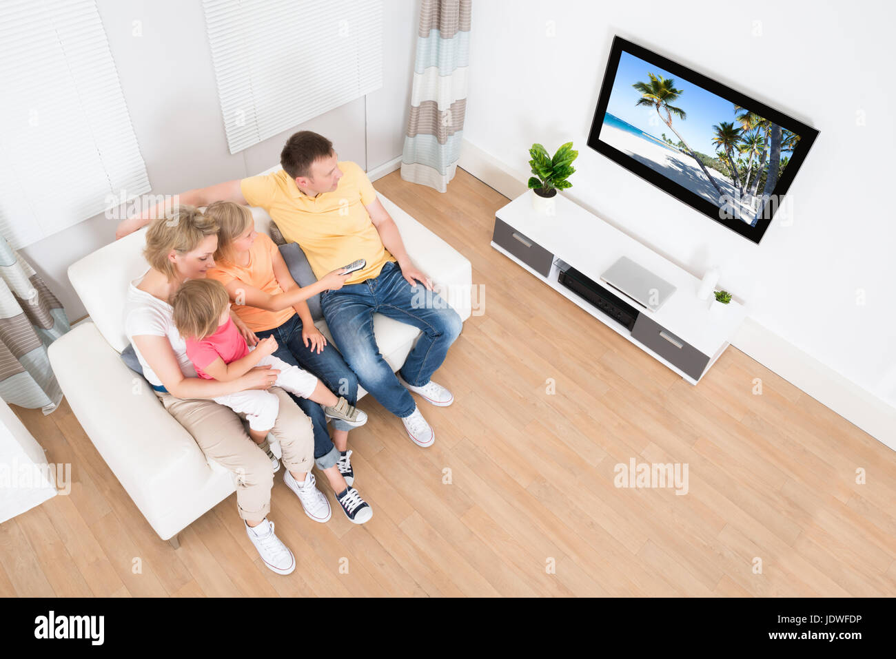 Young Family Watching TV Together At Home Stock Photo - Alamy