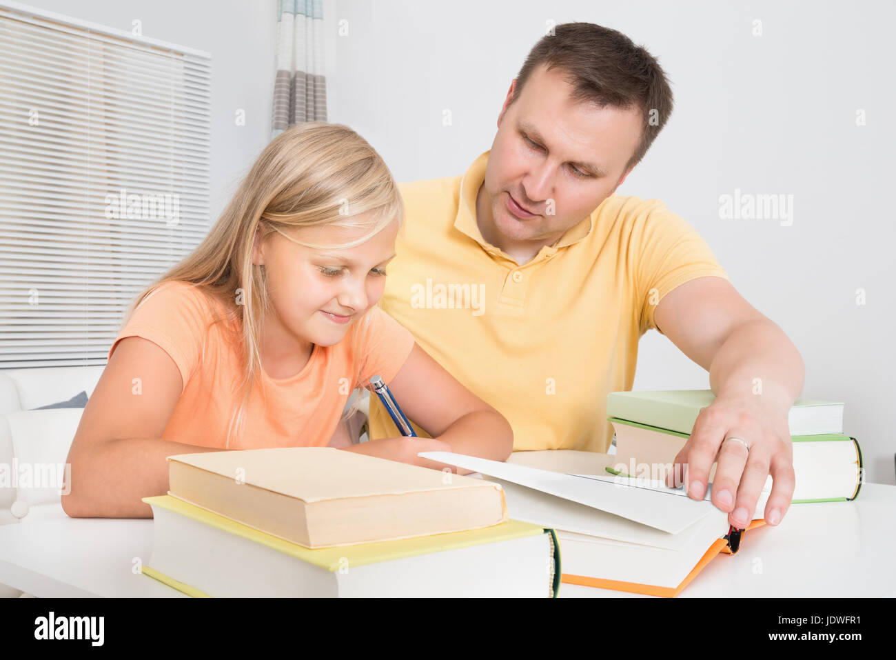 Father Helping Daughter With Homework At Home Stock Photo - Alamy