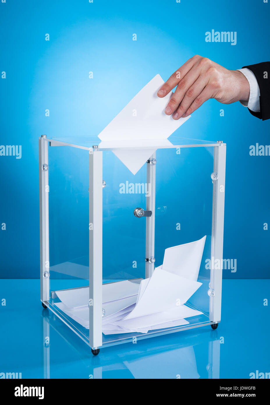 Cropped image of businessman putting paper in polling box against blue ...