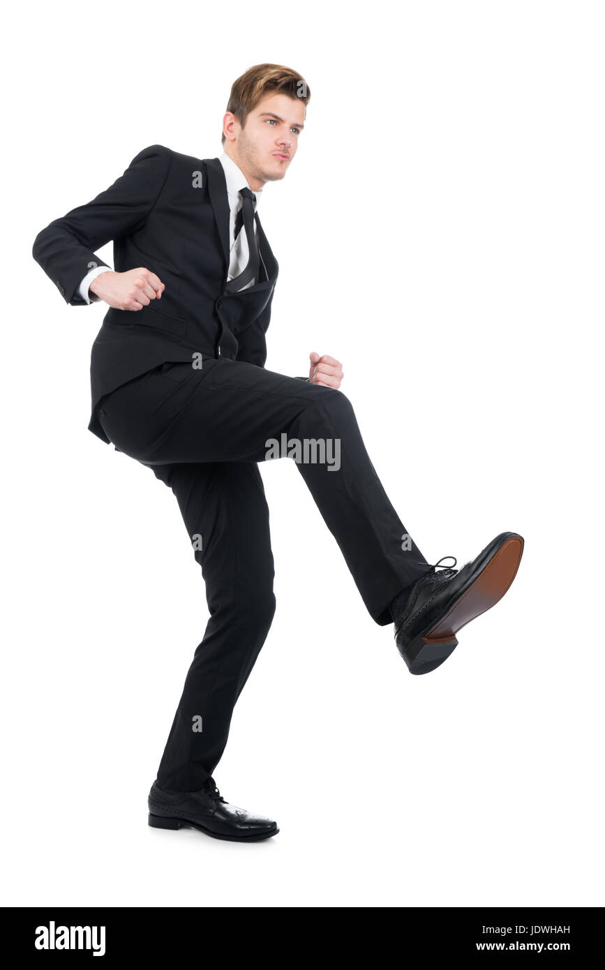 Full length of angry businessman kicking against white background Stock ...