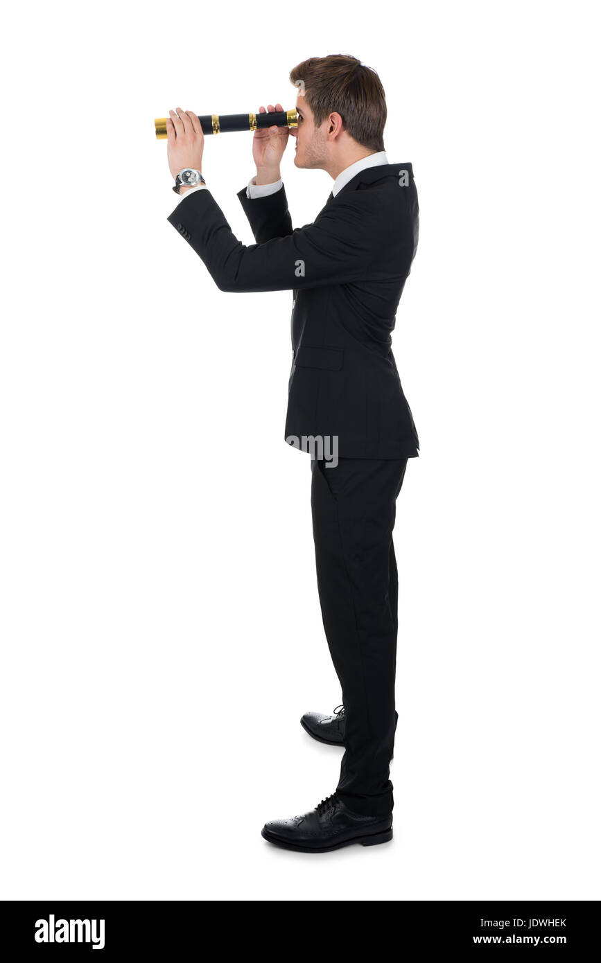 Full length side view of businessman looking through handheld telescope ...