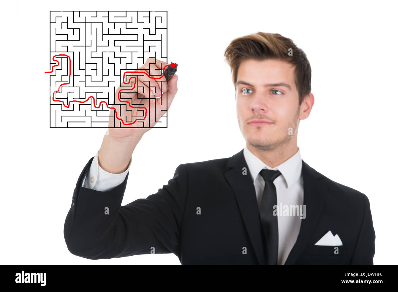 Young businessman solving maze puzzle on transparent screen over white ...