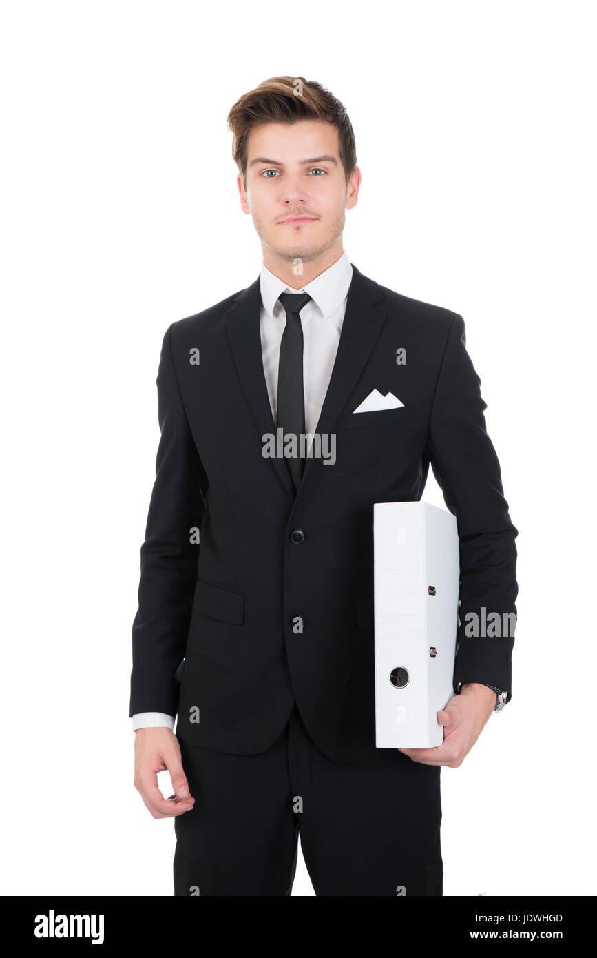 Portrait of confident businessman holding folder against white ...