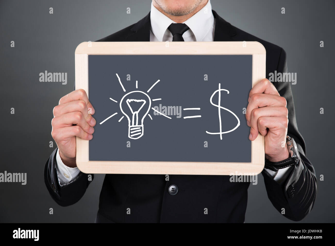 Midsection of young businessman holding slate with idea equation over ...