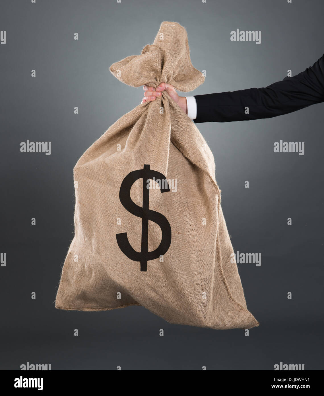 Cropped image of businessman carrying sack with dollar sign against ...