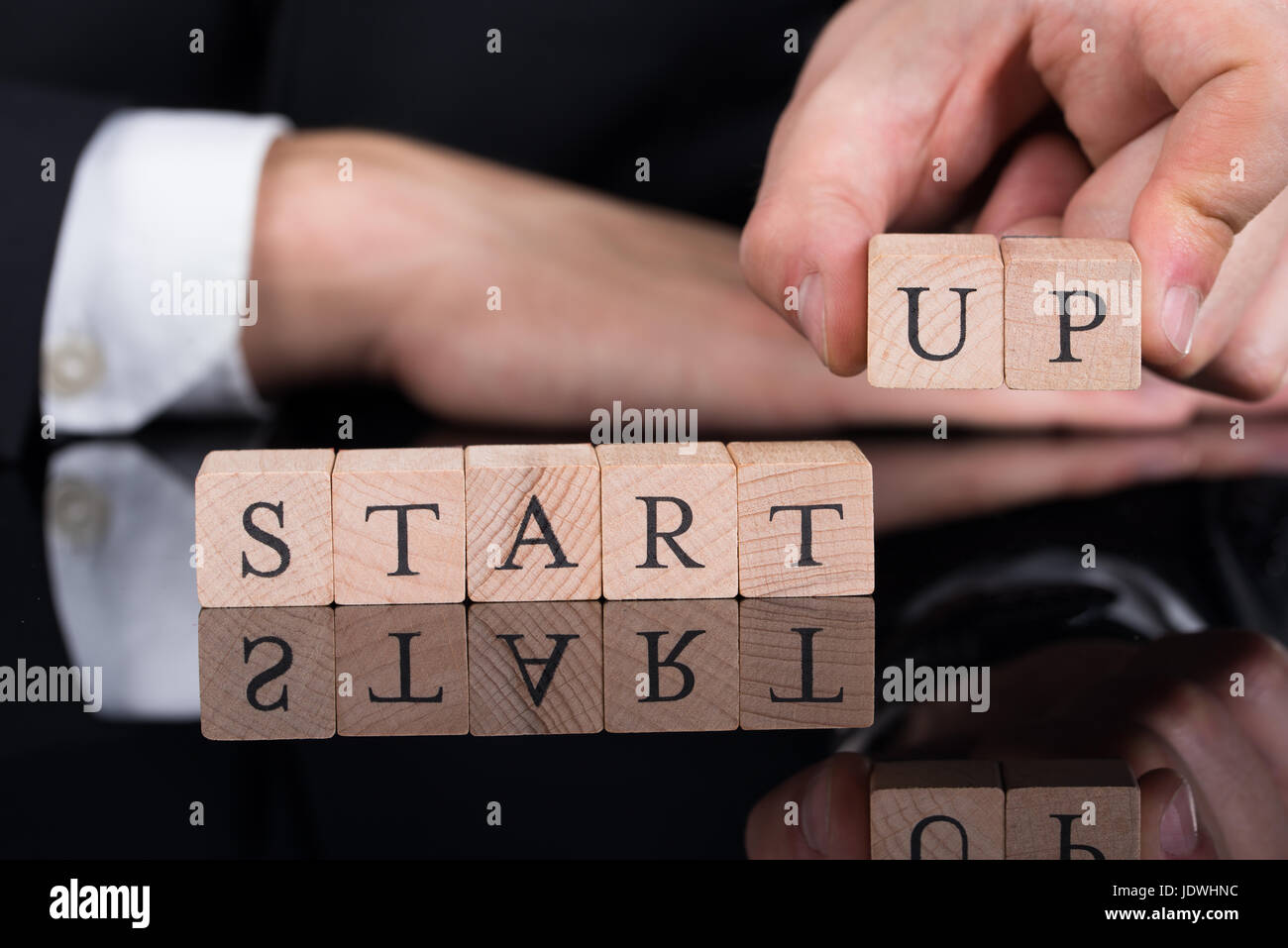 Cropped image of businessman arranging Startup blocks on desk Stock ...