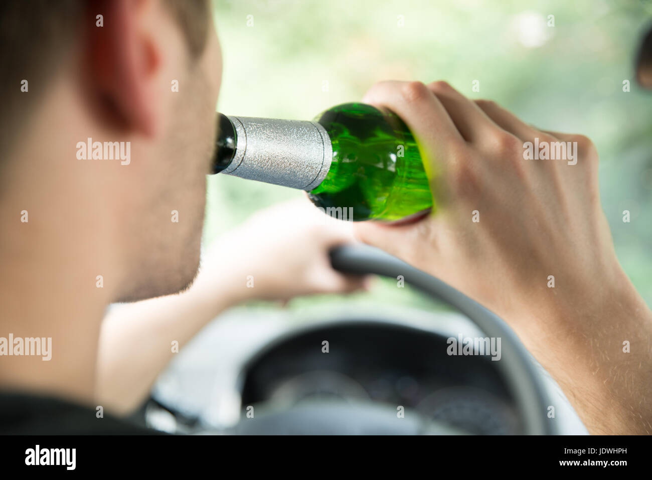 Cropped image of man drinking alcohol while driving car Stock Photo - Alamy