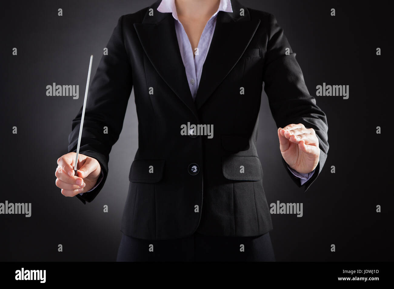 Close-up Of Female Orchestra Conductor Holding Baton Over Black ...
