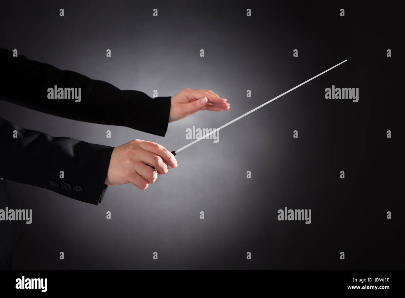 Close-up Of Female Orchestra Conductor Holding Baton Over Black ...