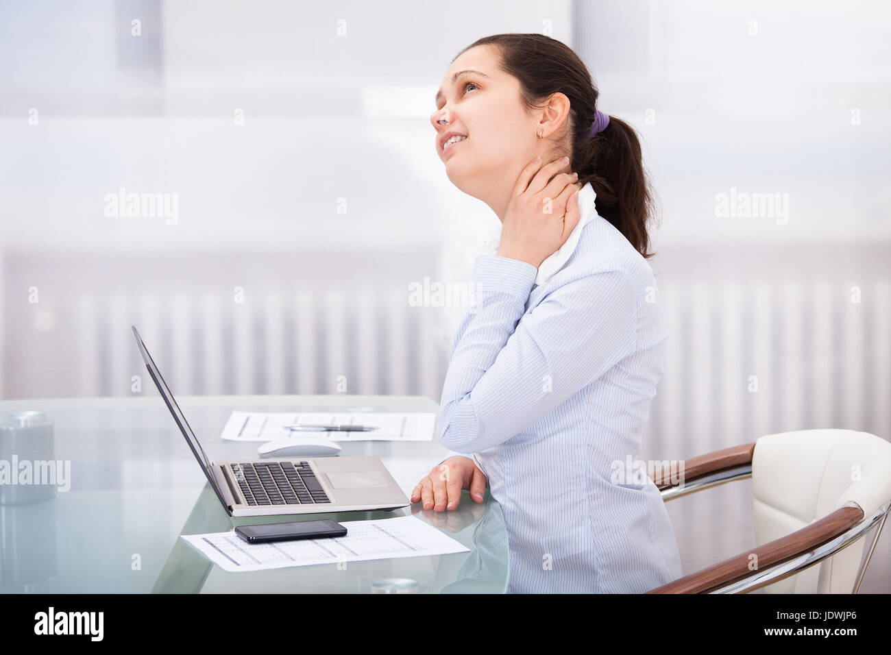 Young Businesswoman Having Pain In Neck At Workplace Stock Photo - Alamy