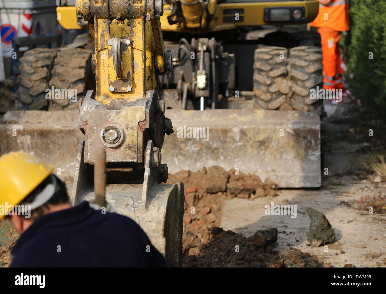 Works on a road construction site with the digger and the worker inside ...
