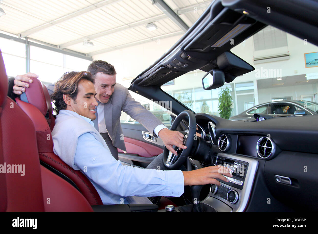 Car seller showing interior details to purchaser Stock Photo - Alamy