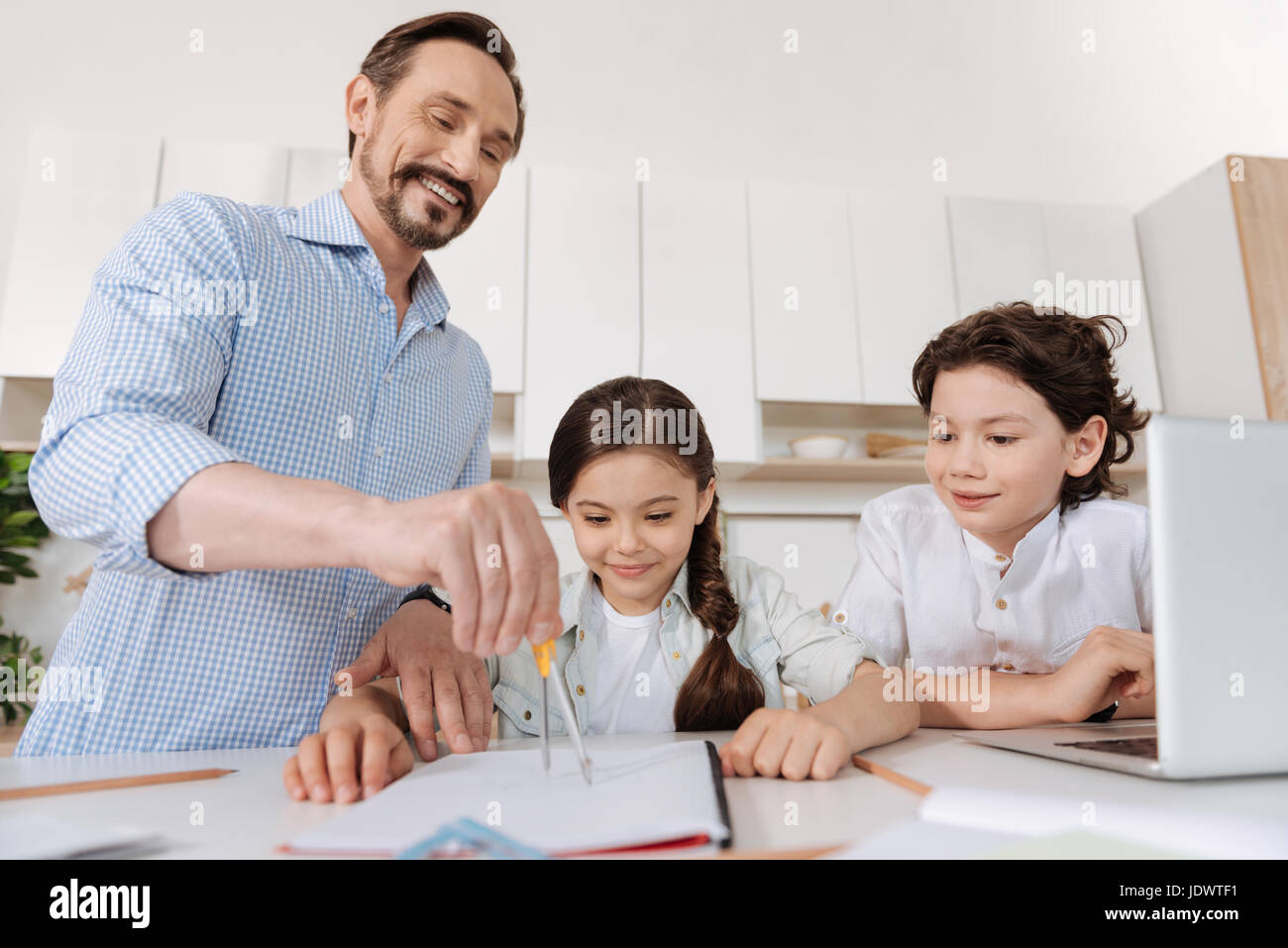 Curious children watching their father using compass Stock Photo - Alamy