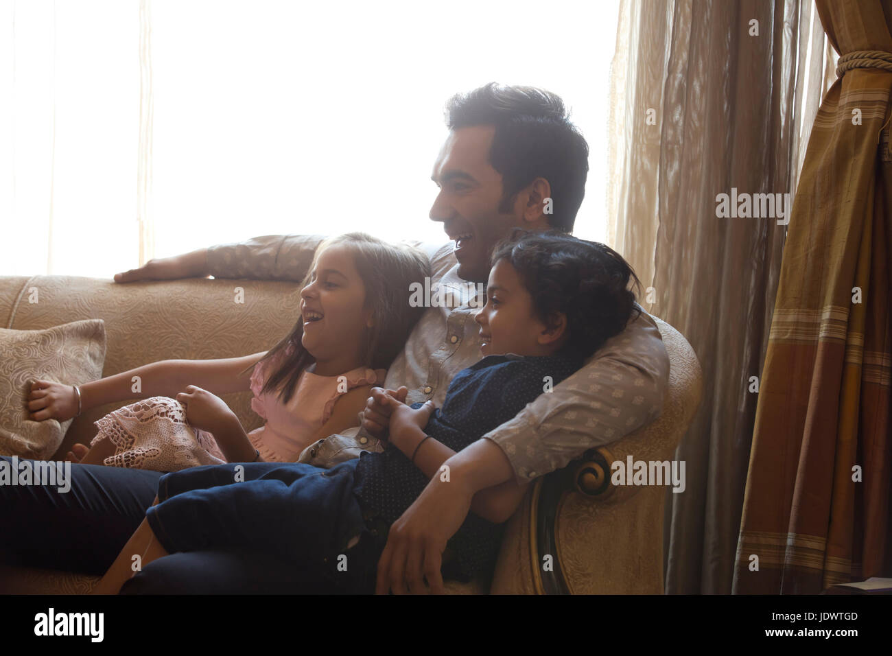 Father and son sitting side by side on sofa hi-res stock photography ...