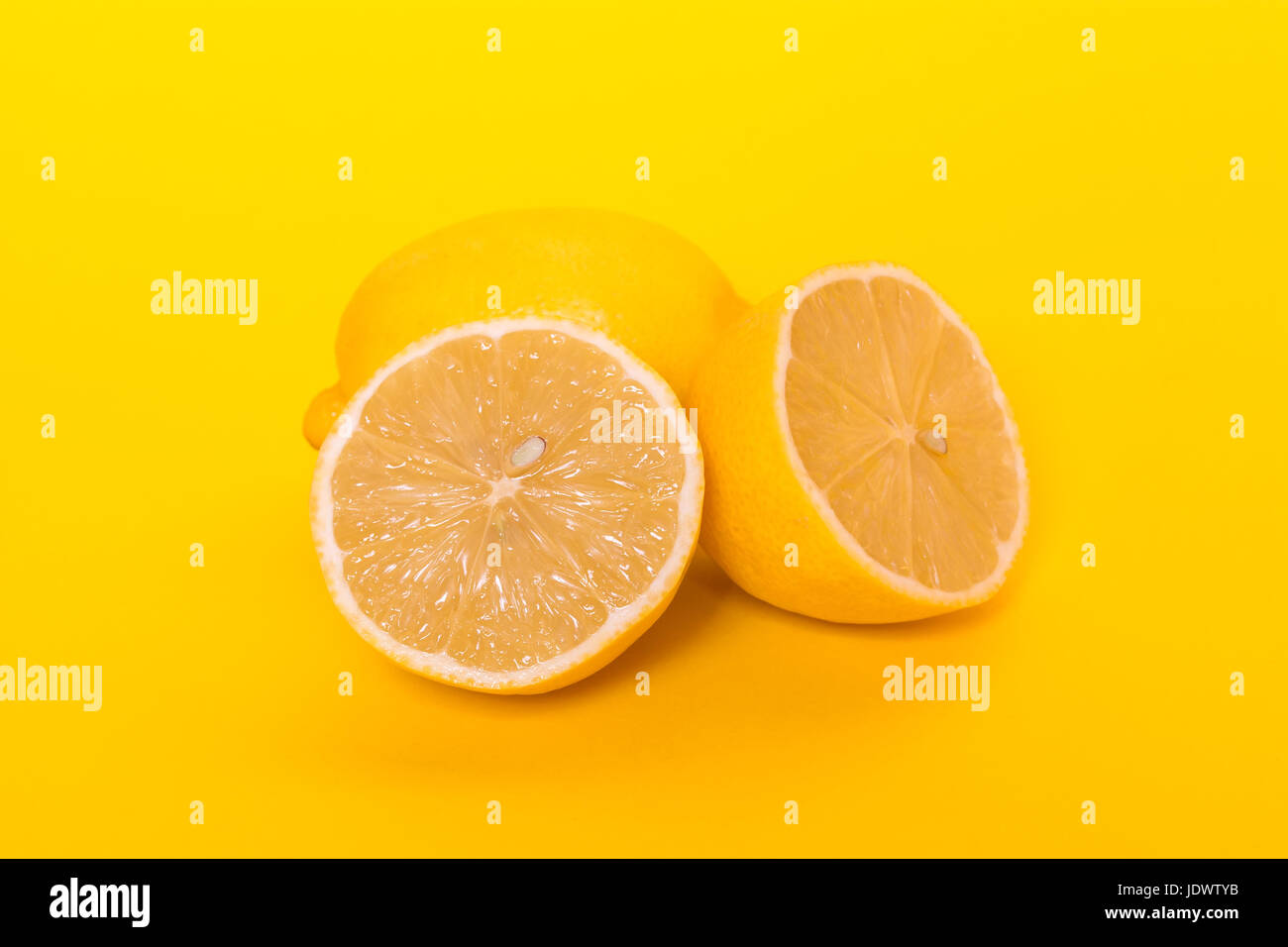 Lemon and half a lemons on a yellow background. Ripe tropical fruit ...