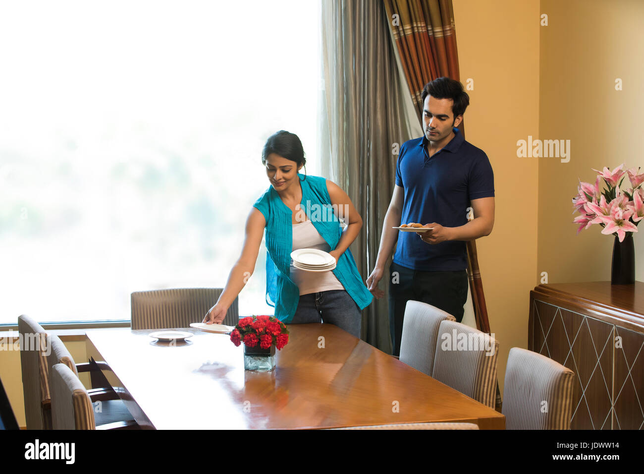 Couple setting dining table Stock Photo - Alamy