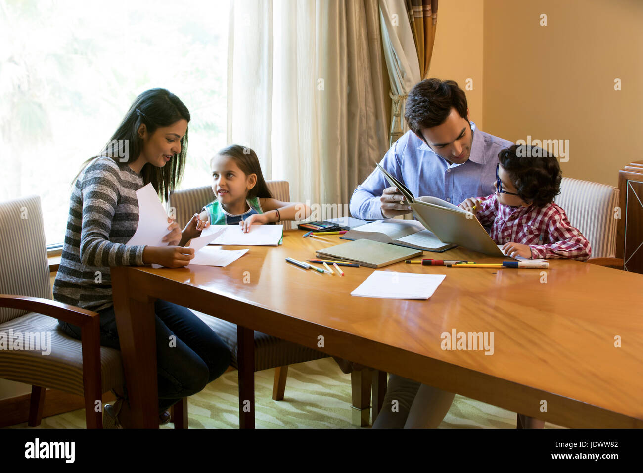 Parents helping daughters with homework Stock Photo - Alamy