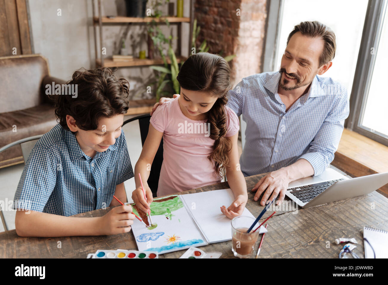 Sweet inspired children finishing up a landscape picture Stock Photo ...