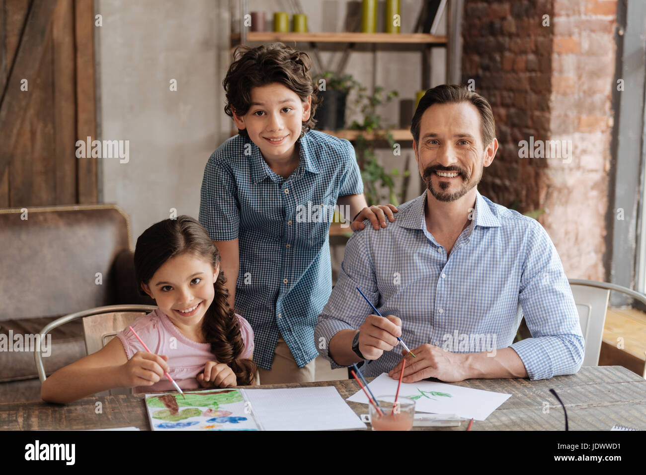 Lovable family posing near the table in living room Stock Photo - Alamy