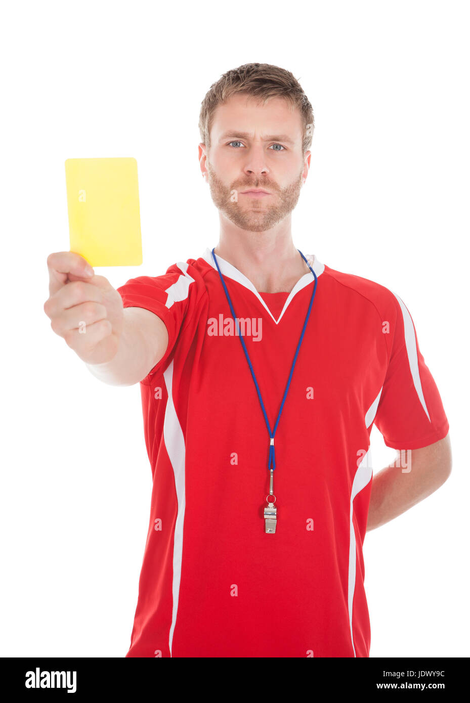 Portrait of referee blowing whistle while showing yellow card over ...