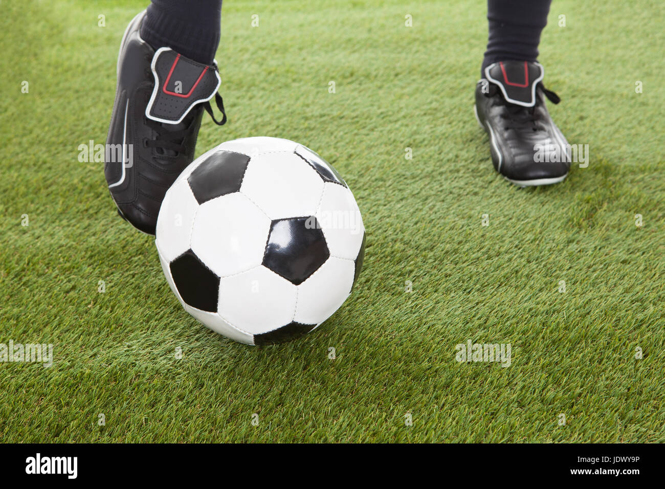 Low section of player's leg on soccer ball at playing field Stock Photo ...
