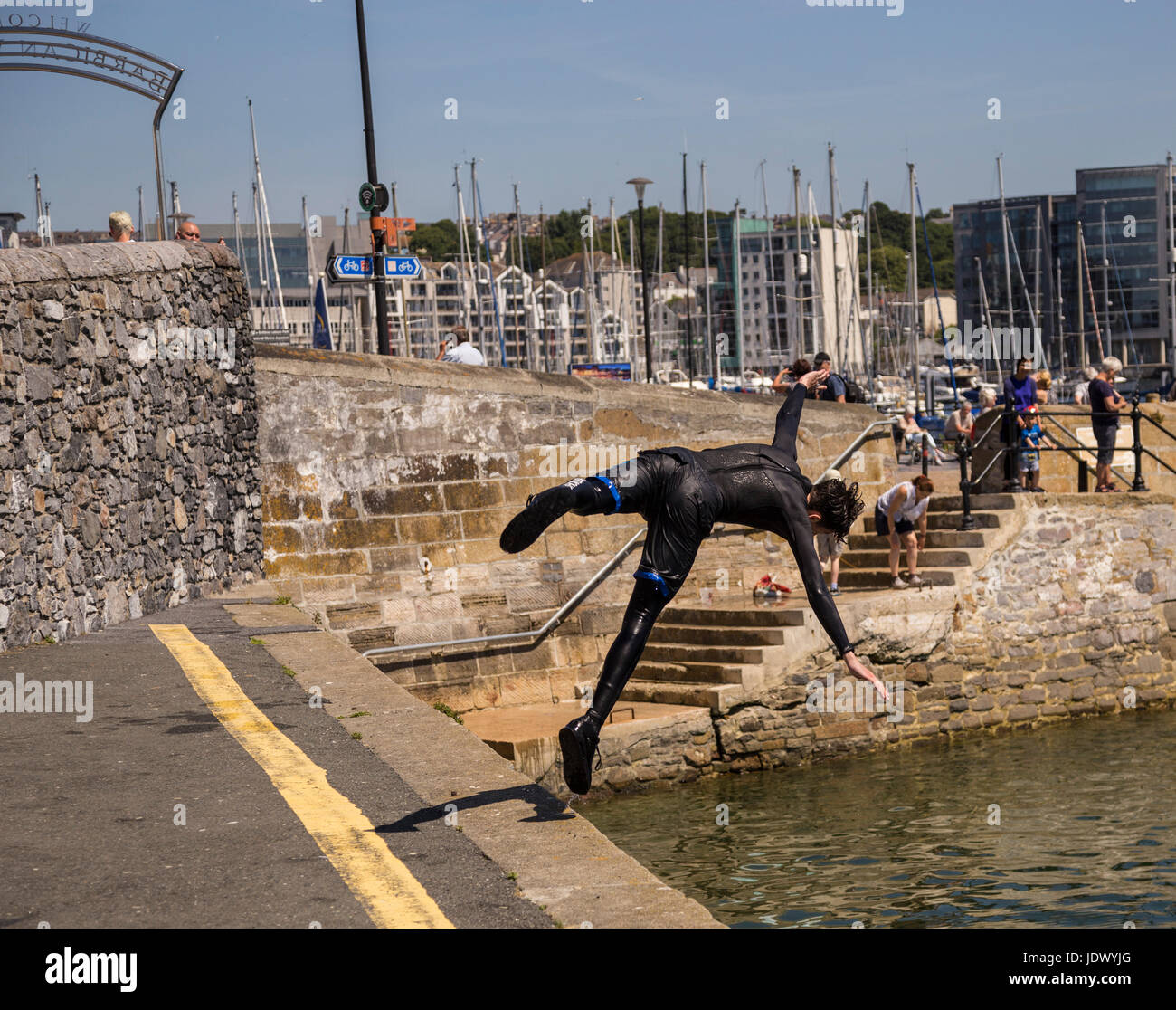 A boy dives into the water at Barbican Wharves, Plymouth Harbour Stock ...