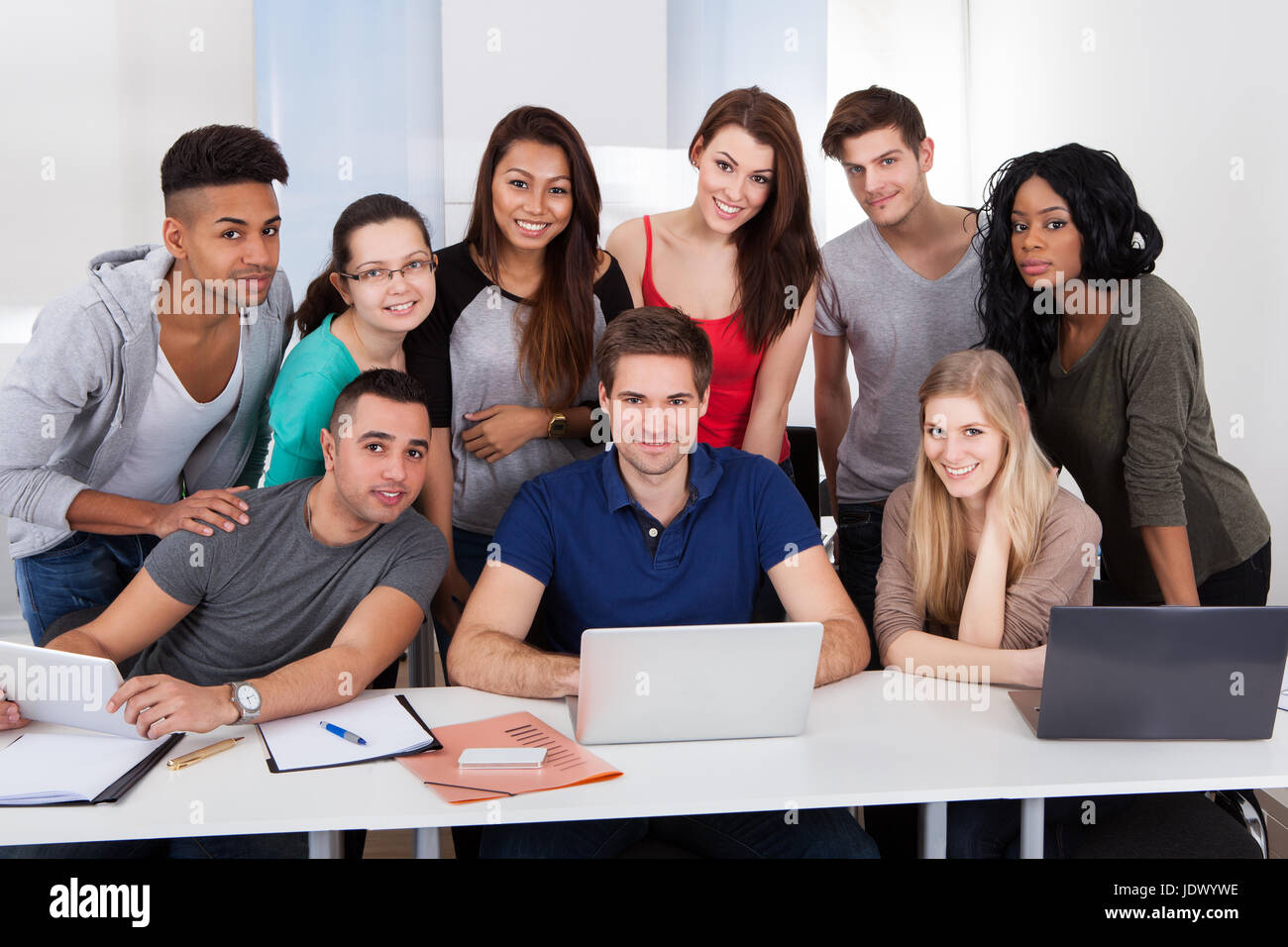 Group of multiethnic university students using laptop together in ...