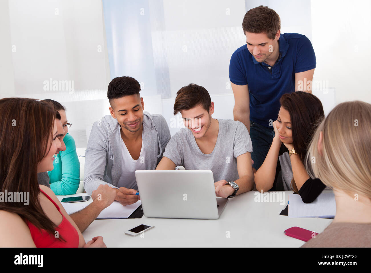 Multiethnic university students using laptop at desk in classroom Stock ...