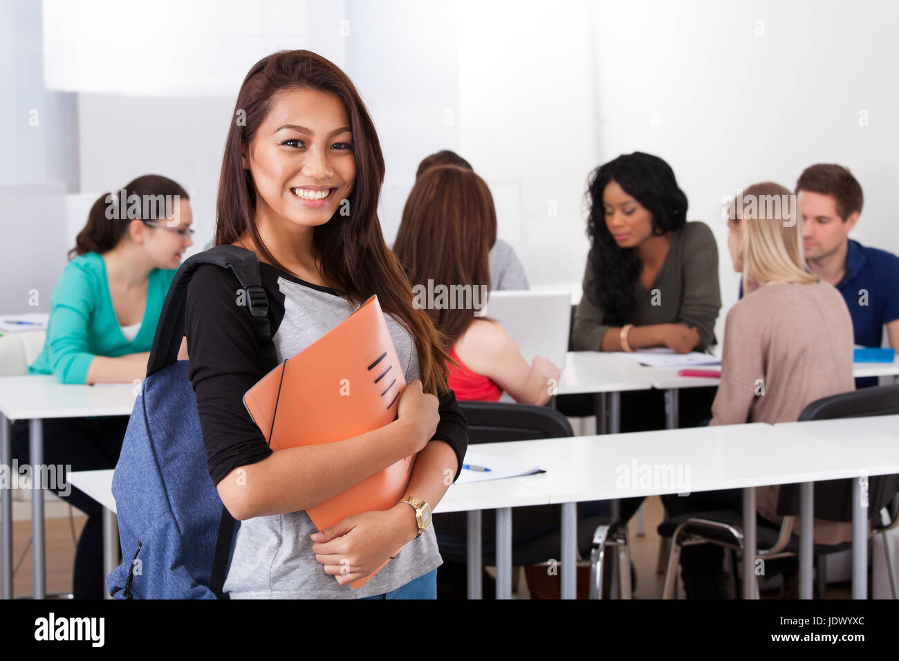 Portrait of confident female college student carrying backpack with ...