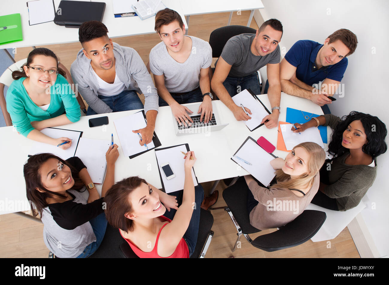 High angle view of university students doing group study at desk in ...