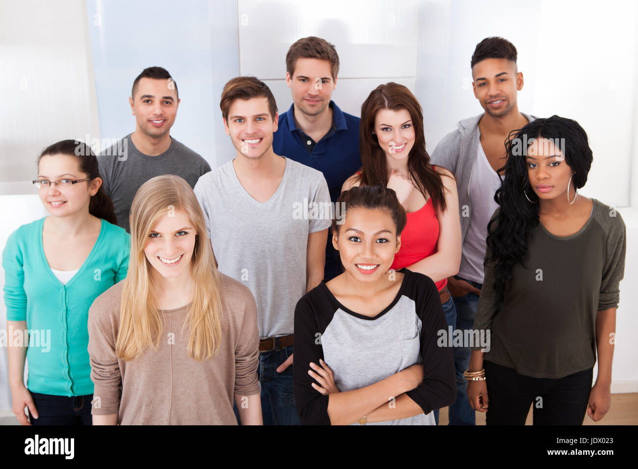 Group portrait of smiling multiethnic college students standing together in classroom Stock ...