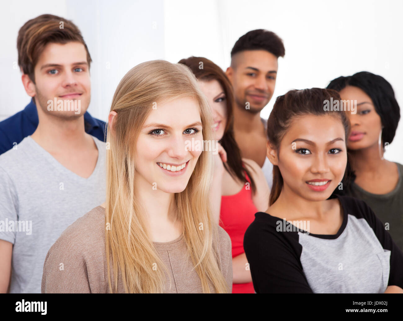 Group portrait of smiling multiethnic college students standing together in classroom Stock ...