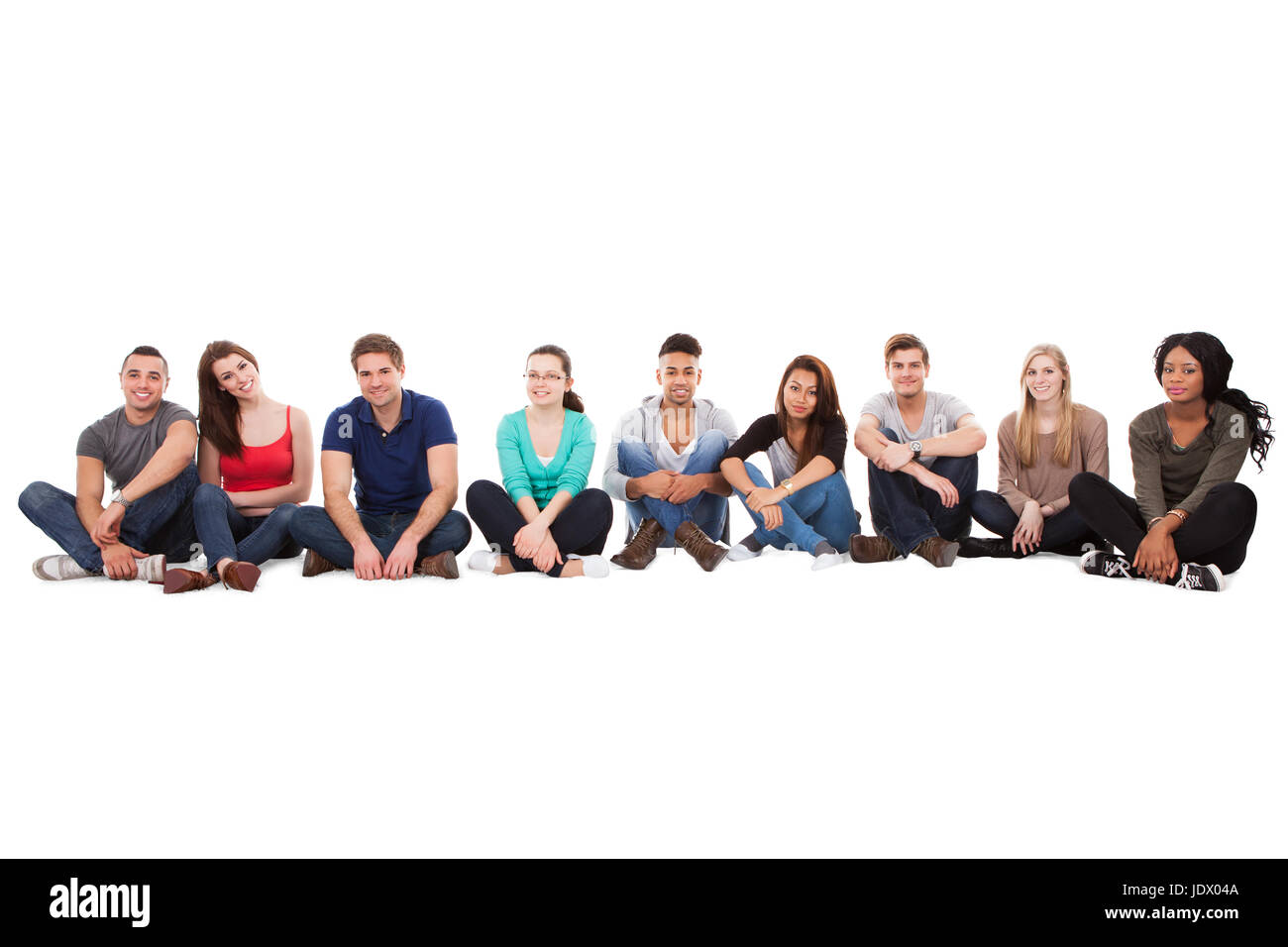 Full length portrait of multiethnic college students sitting in a row ...