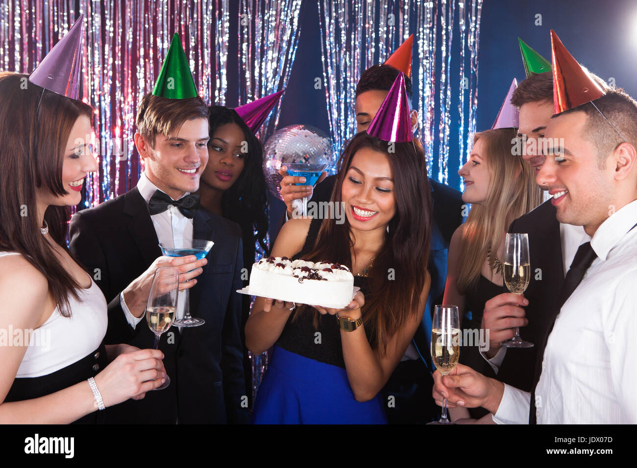 Beautiful young woman celebrating birthday with friends at nightclub ...