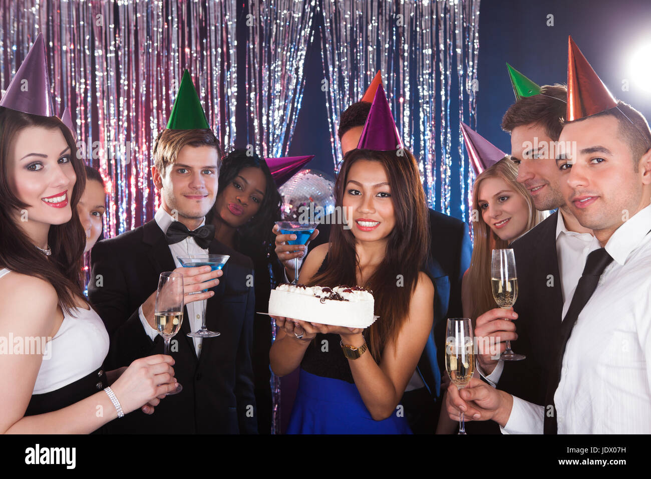 Beautiful young woman celebrating birthday with friends at nightclub ...