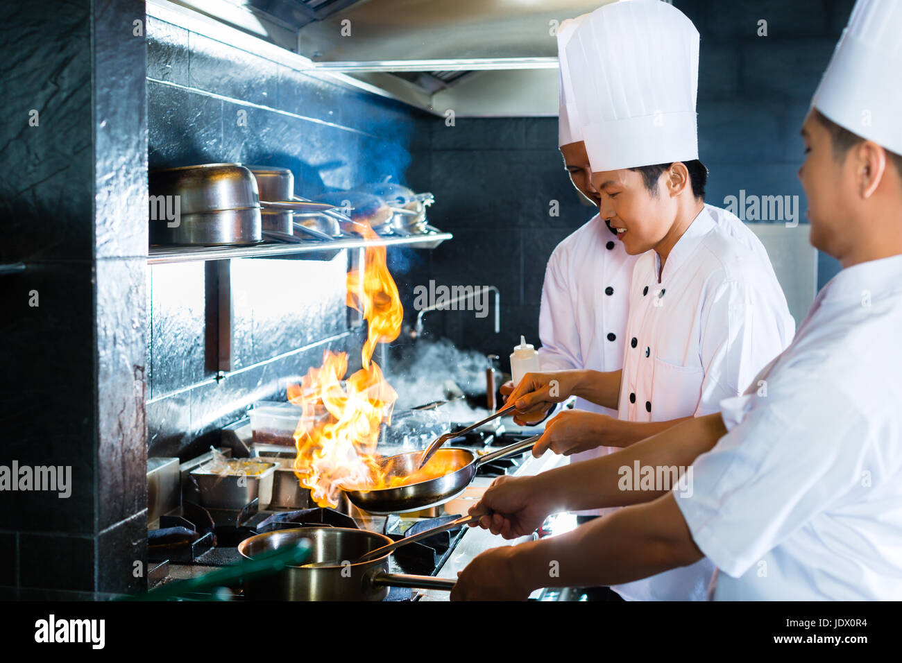 Side view of chefs cooking together Stock Photo - Alamy