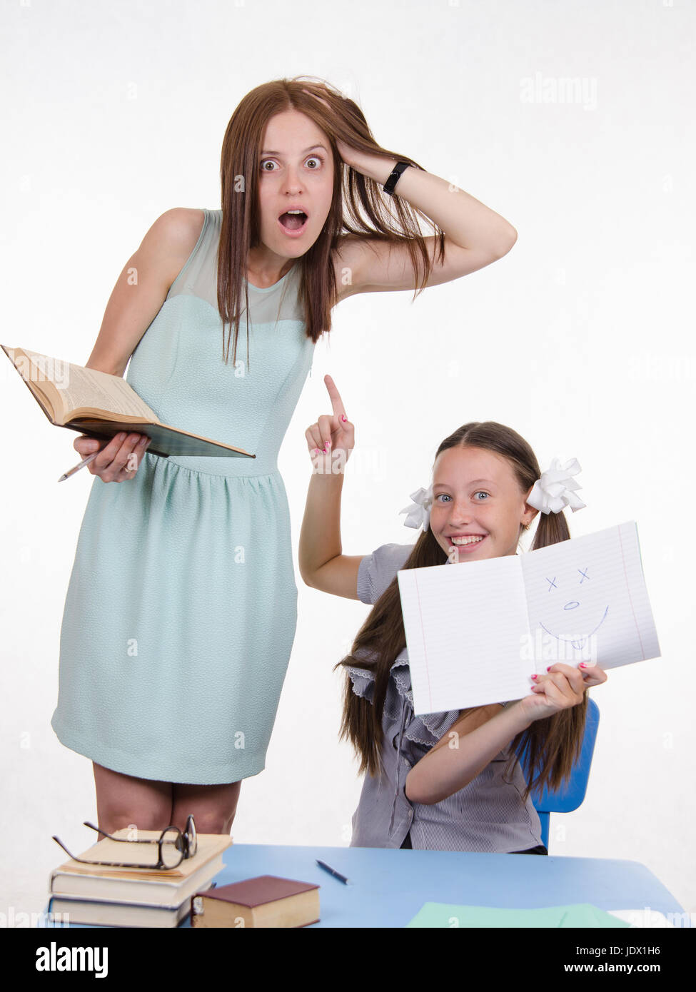 Teacher standing at desk behind which sits student who drew a funny ...