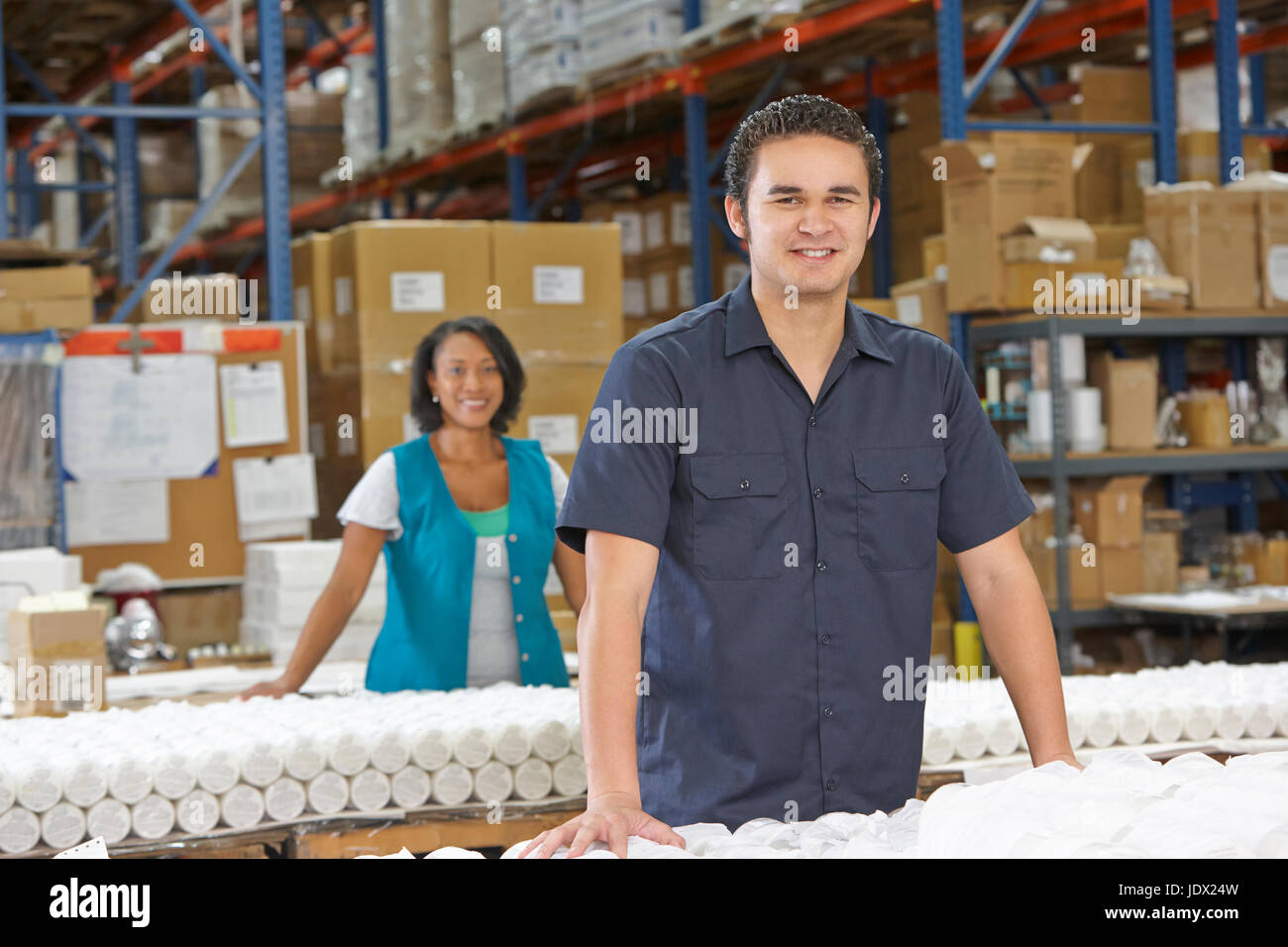 Factory Worker Checking Goods On Production Line Stock Photo - Alamy