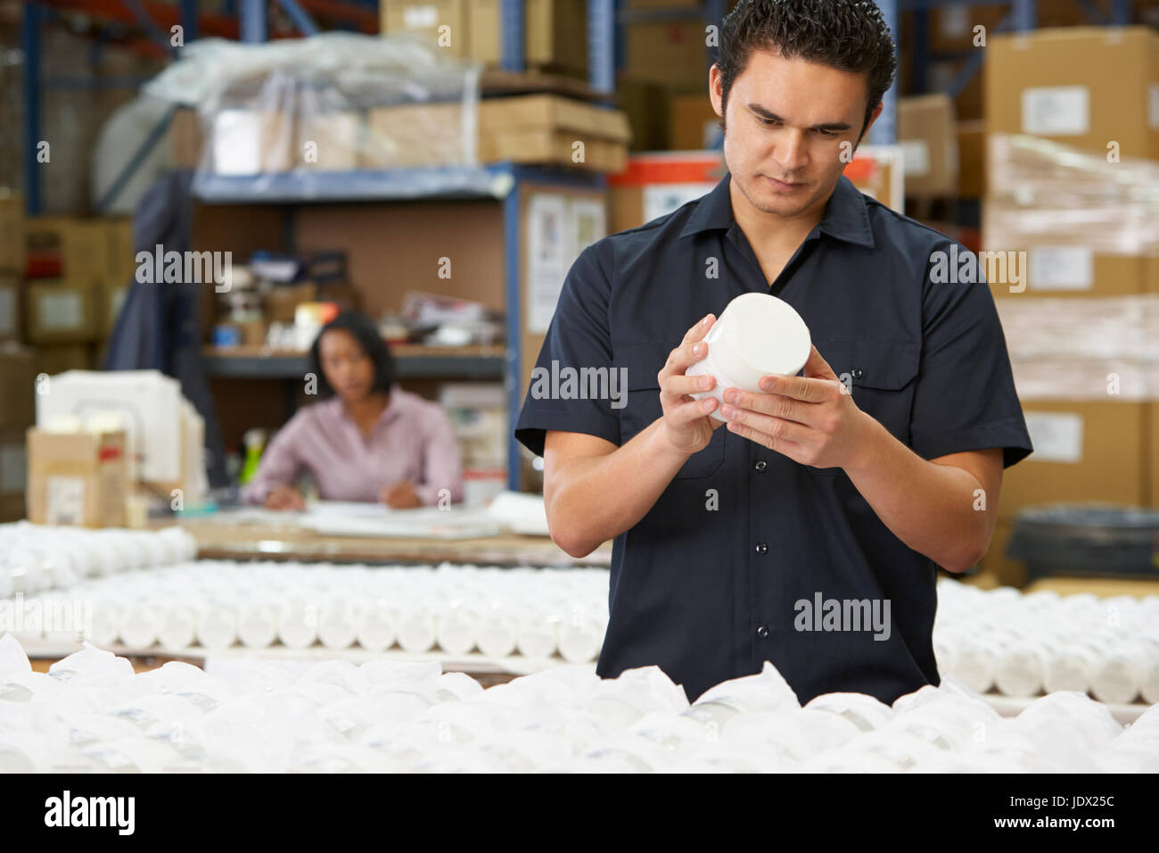 Factory Worker Checking Goods On Production Line Stock Photo - Alamy