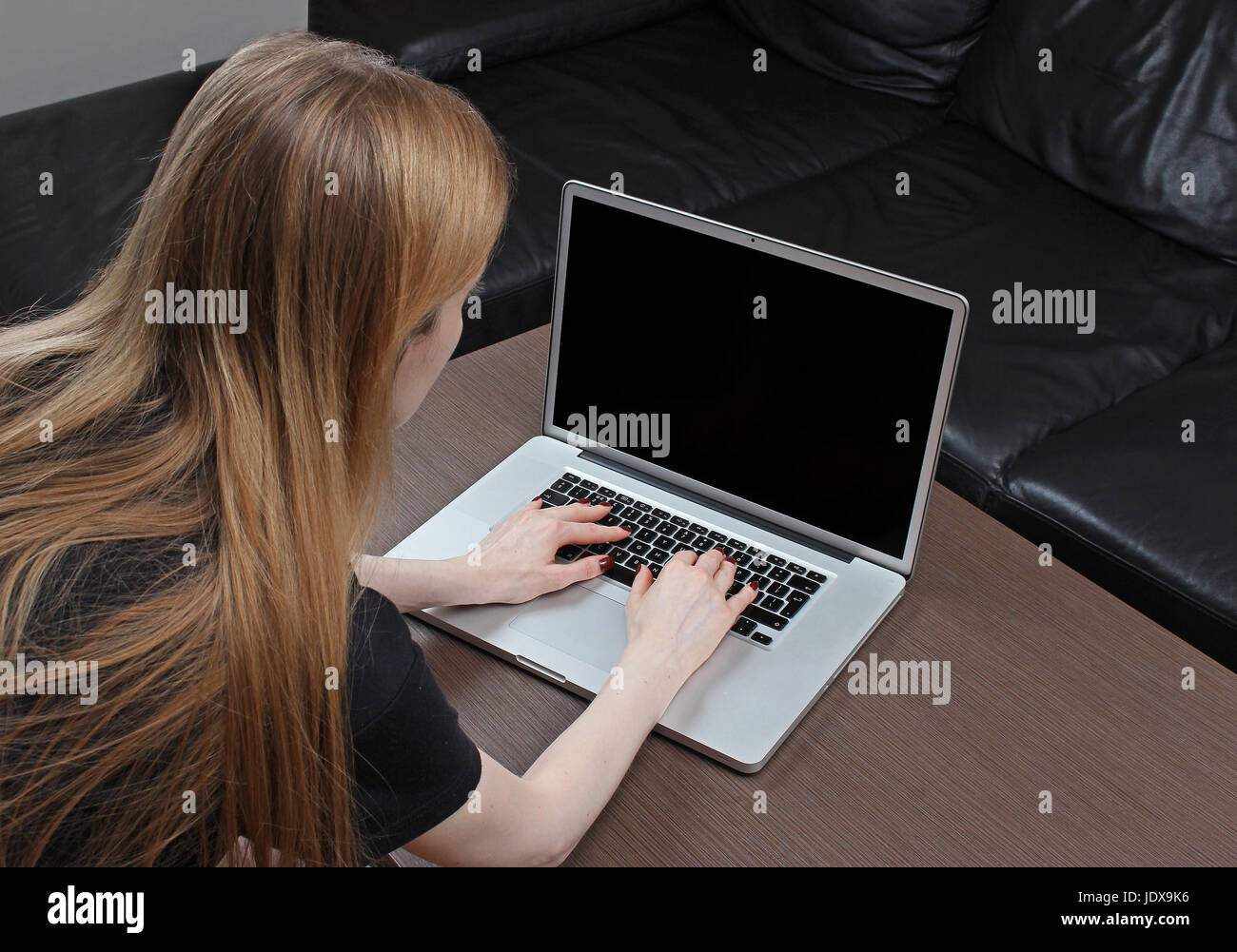 Young teenage girl from back typing on laptop keyboard with empty ...