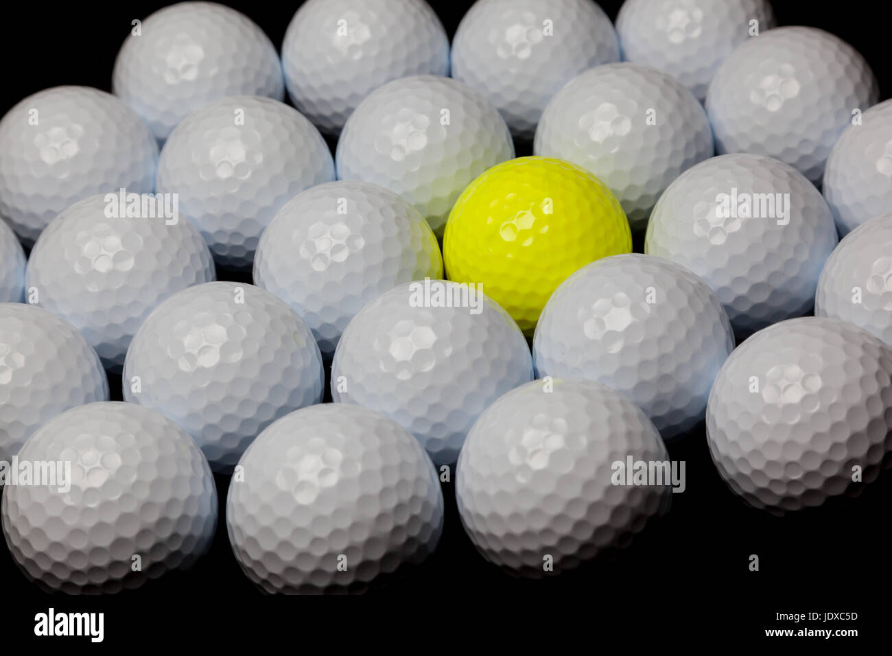 Single yellow golf ball mixed with many white balls. Alternative ...