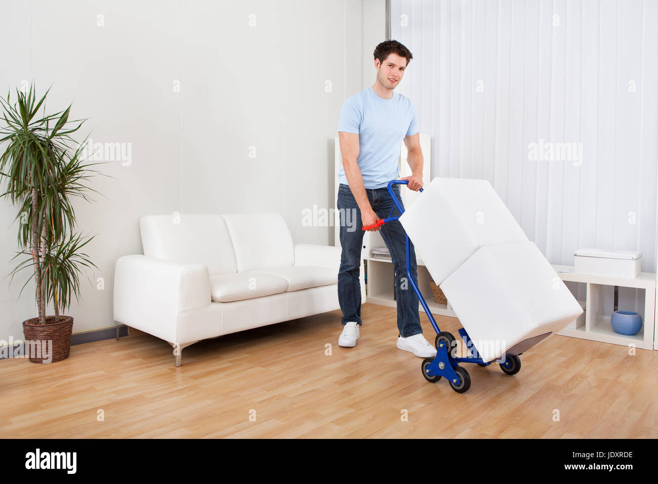 Young Man Holding Trolley Loaded With Cardboard Box Stock Photo - Alamy