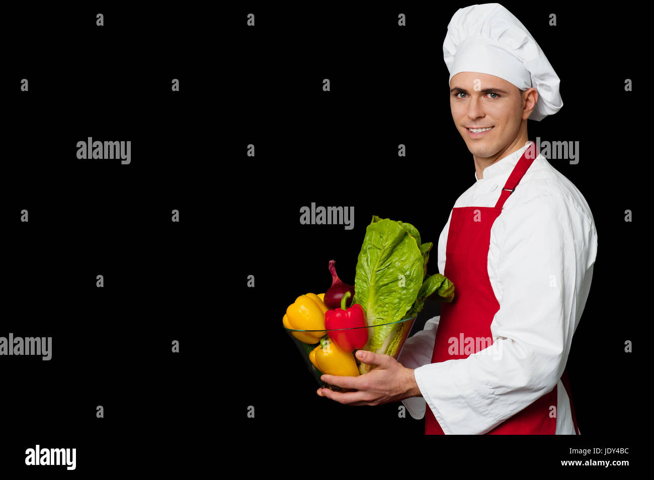 Male chef holding glass bowl full of vegetables Stock Photo - Alamy