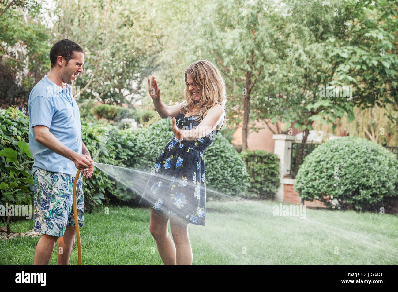 Couple playing garden hose spraying hi-res stock photography and images ...