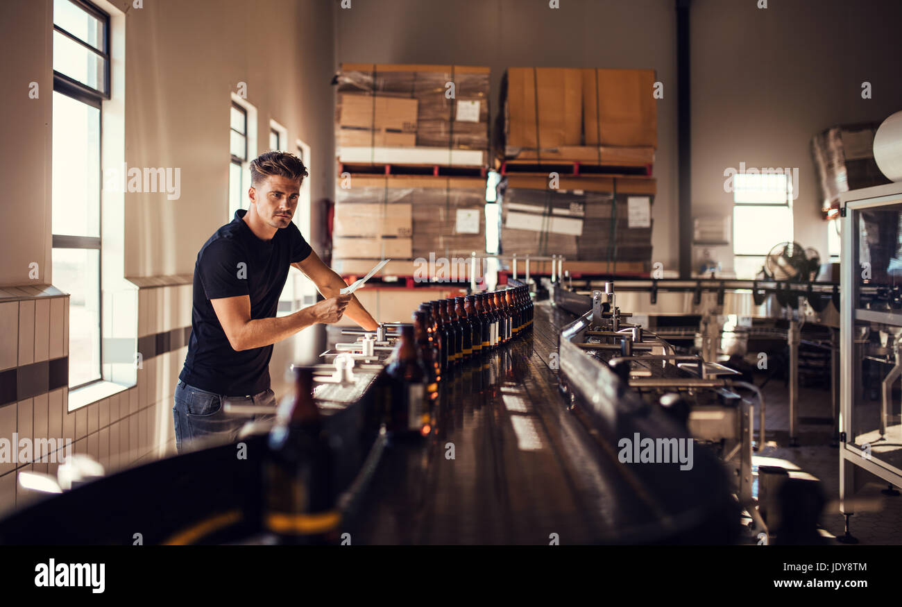 Brewer supervising the process of beer manufacturing in brewery plant ...